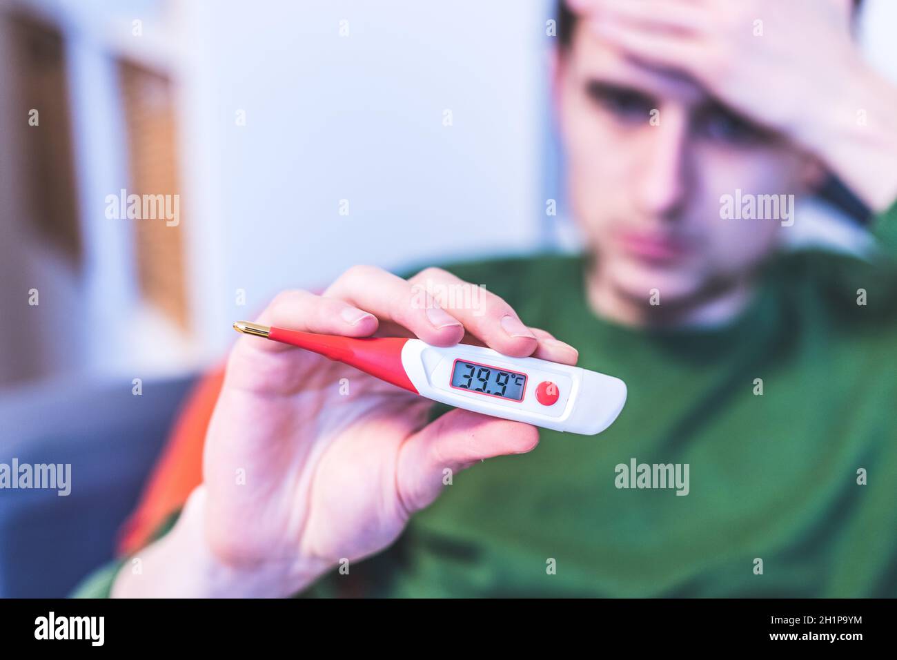Man is holding a red fever thermometer in his hand Stock Photo - Alamy