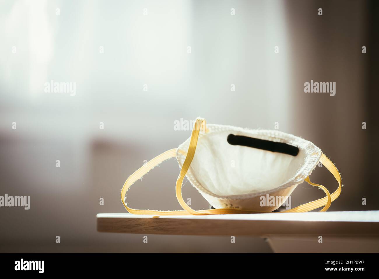 Breathing mask lying on a table. Flue and corona season Stock Photo - Alamy