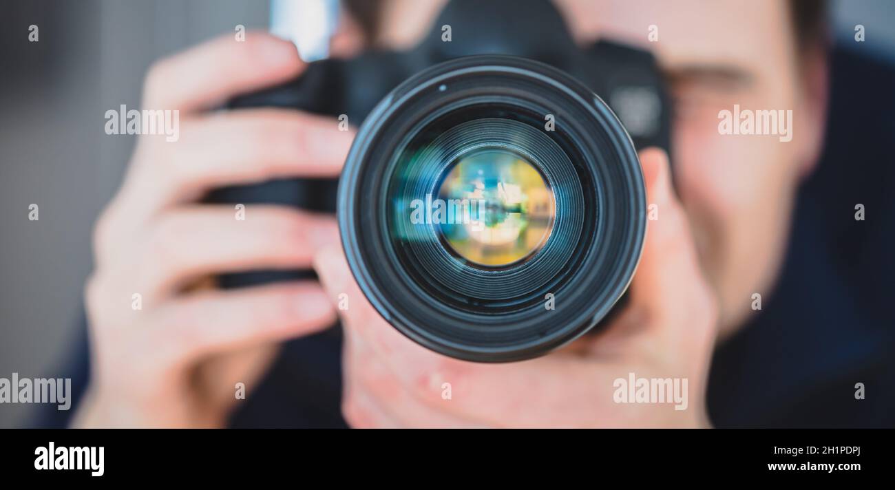 Photographer is standing behind a professional camera with telephoto ...