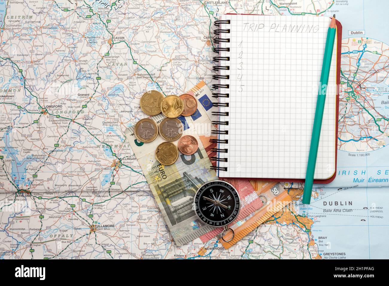 Travel concept with notebook written TRIP PLANNING , compass and money ...
