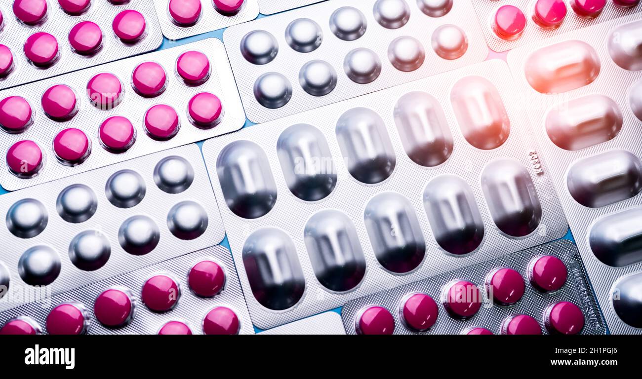 Pink tablets in blister pack and silver aluminium foil pack for capsule ...