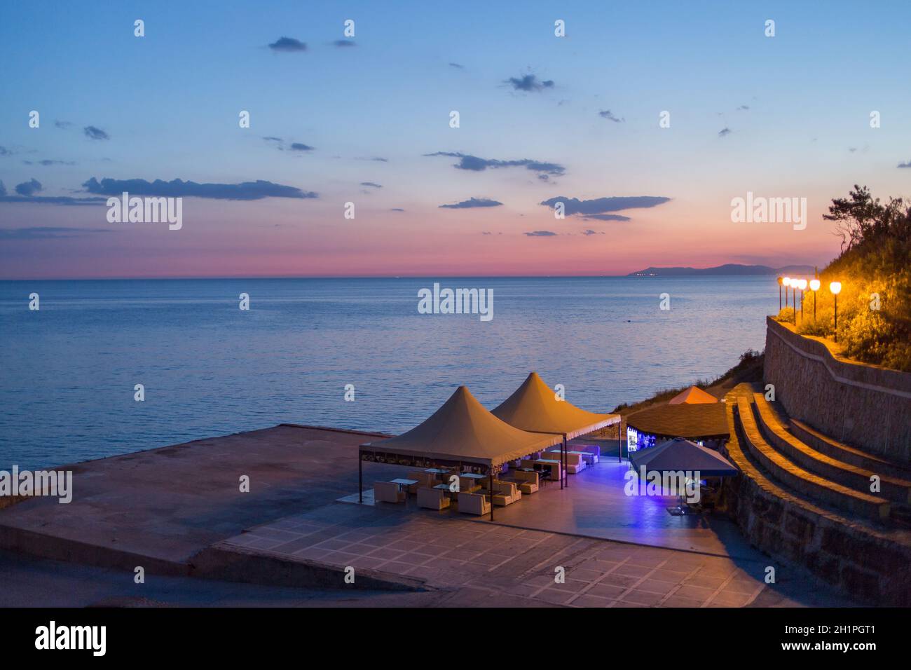 Calm sunset at the seaside, calm at sea. Clouds over the water surface ...