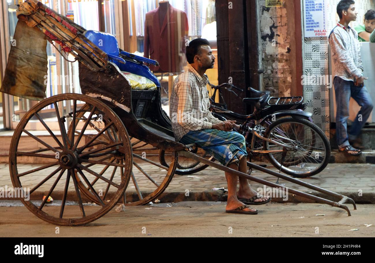 A hand rickshaw puller waits for passengers in his rickshaw in Kolkata ...