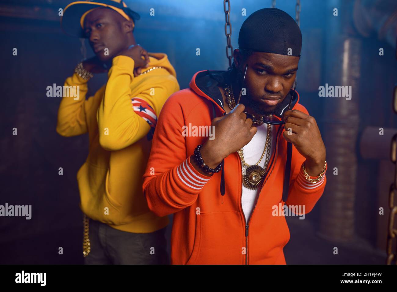 Two stylish rappers poses in studio with cool underground decoration ...