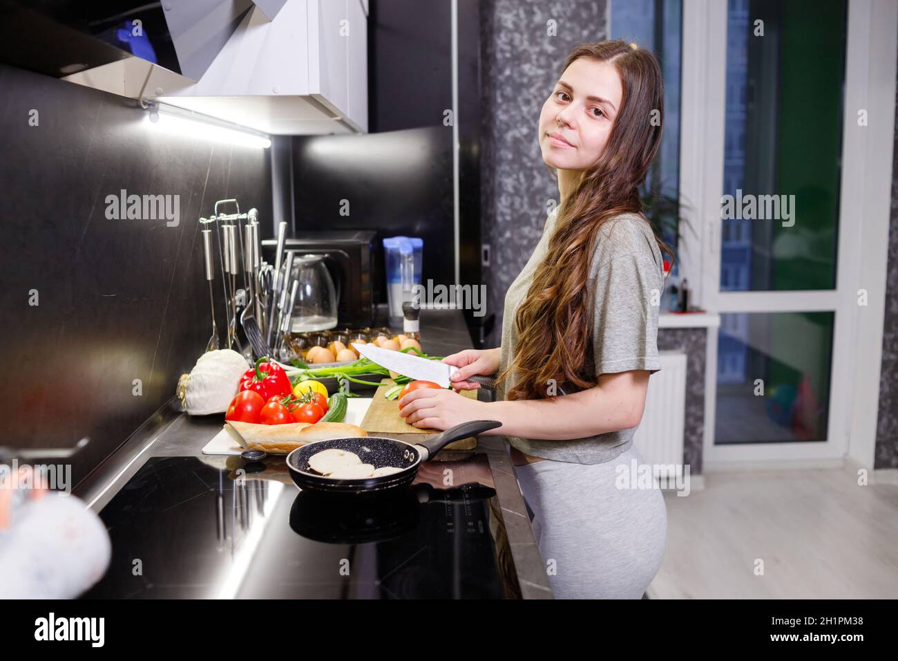 Young woman cooking vegetables in kitchen. Healthy Food. Dieting ...