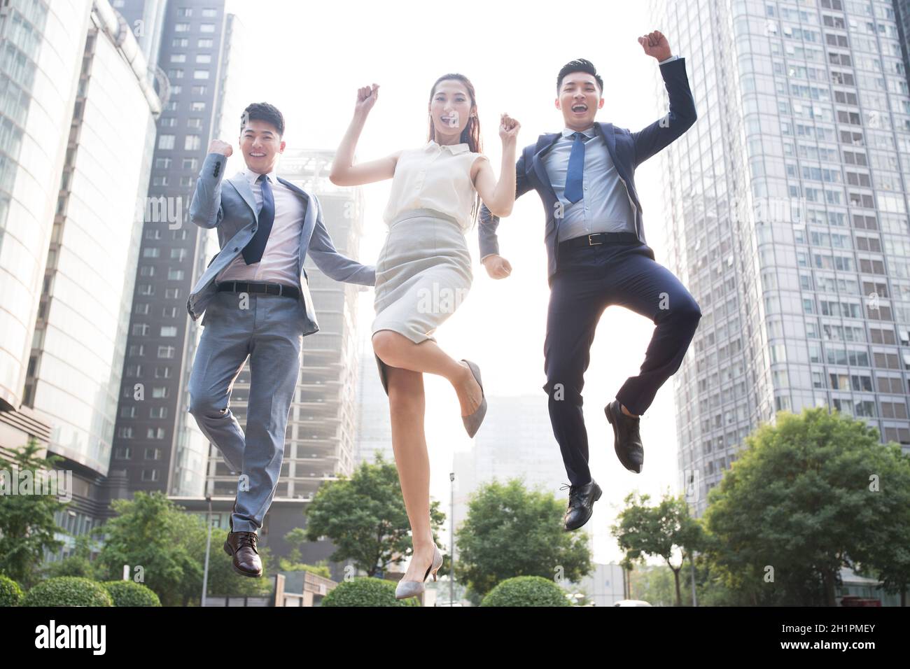Confident business team jumping Stock Photo - Alamy