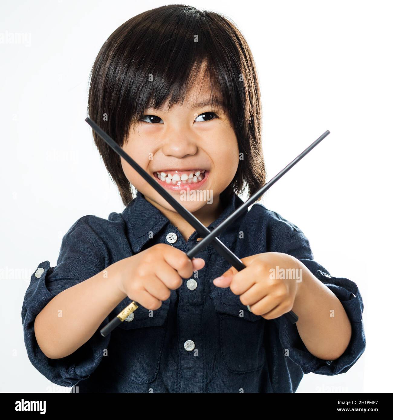 Close up portrait of little asian boy playing with chopsticks.Isolated ...
