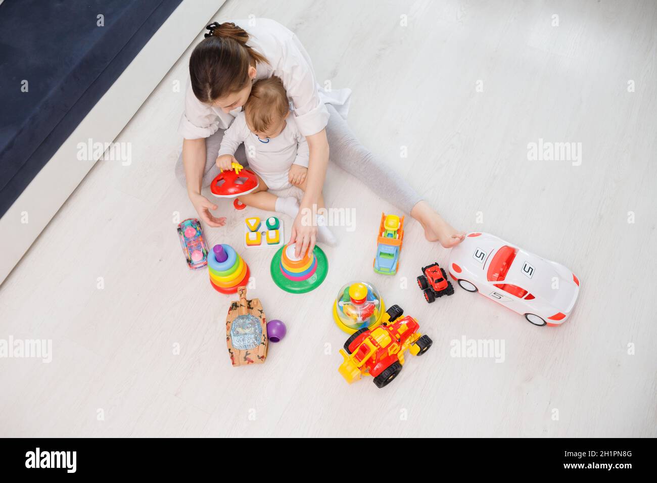 Top view on woman's and child playing with toys wooden on floor Stock ...