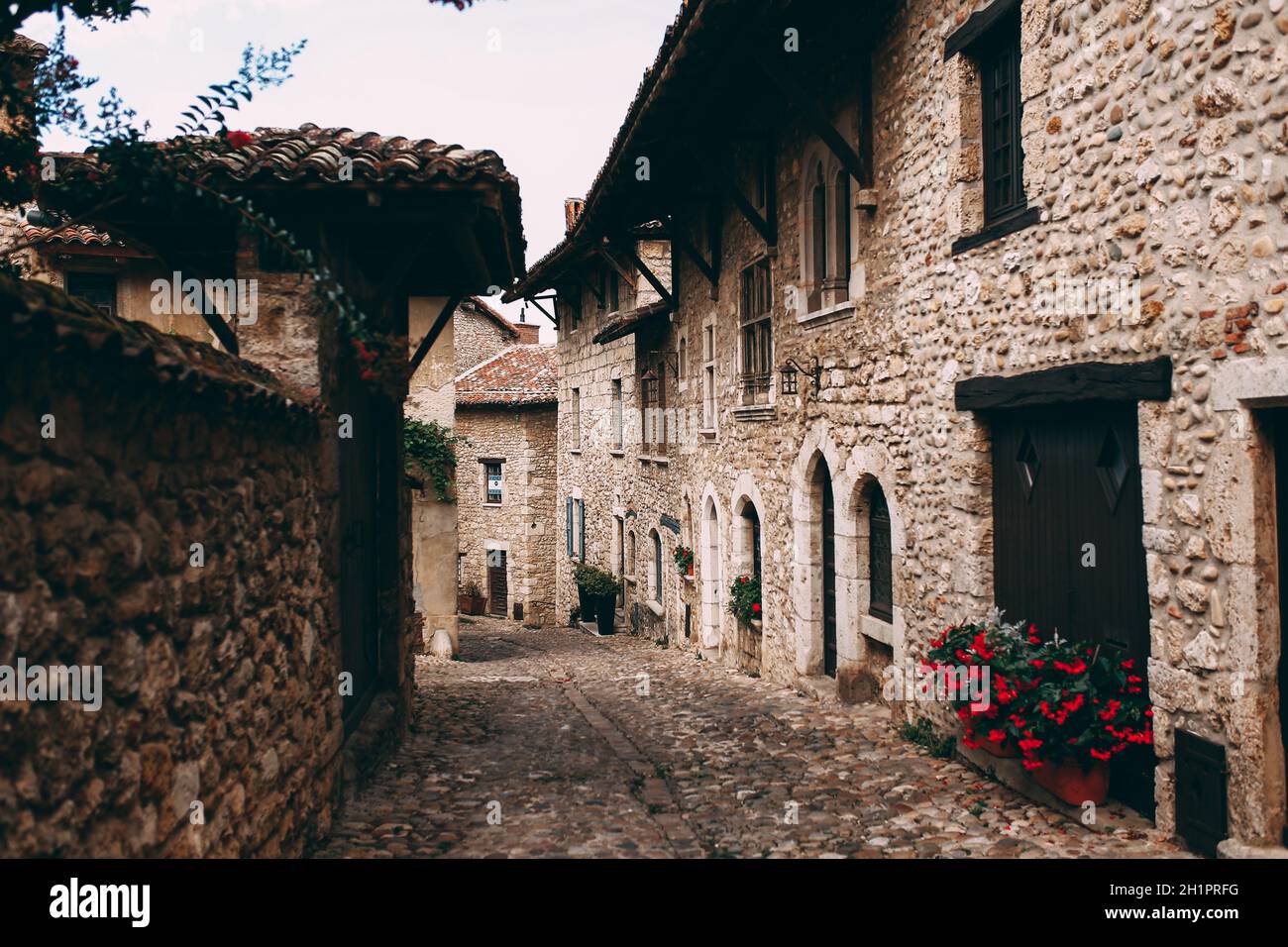 Street with facades of old stone buildings in Perouges, France, red ...