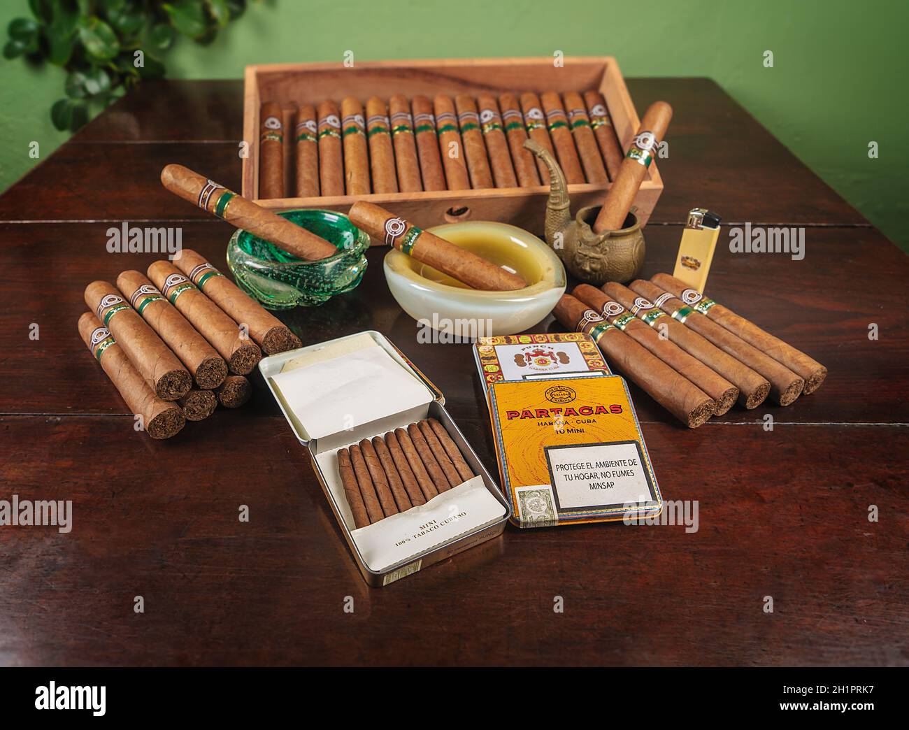 A table with a variety of cigars. Two box of Partagas small cigars, a ...