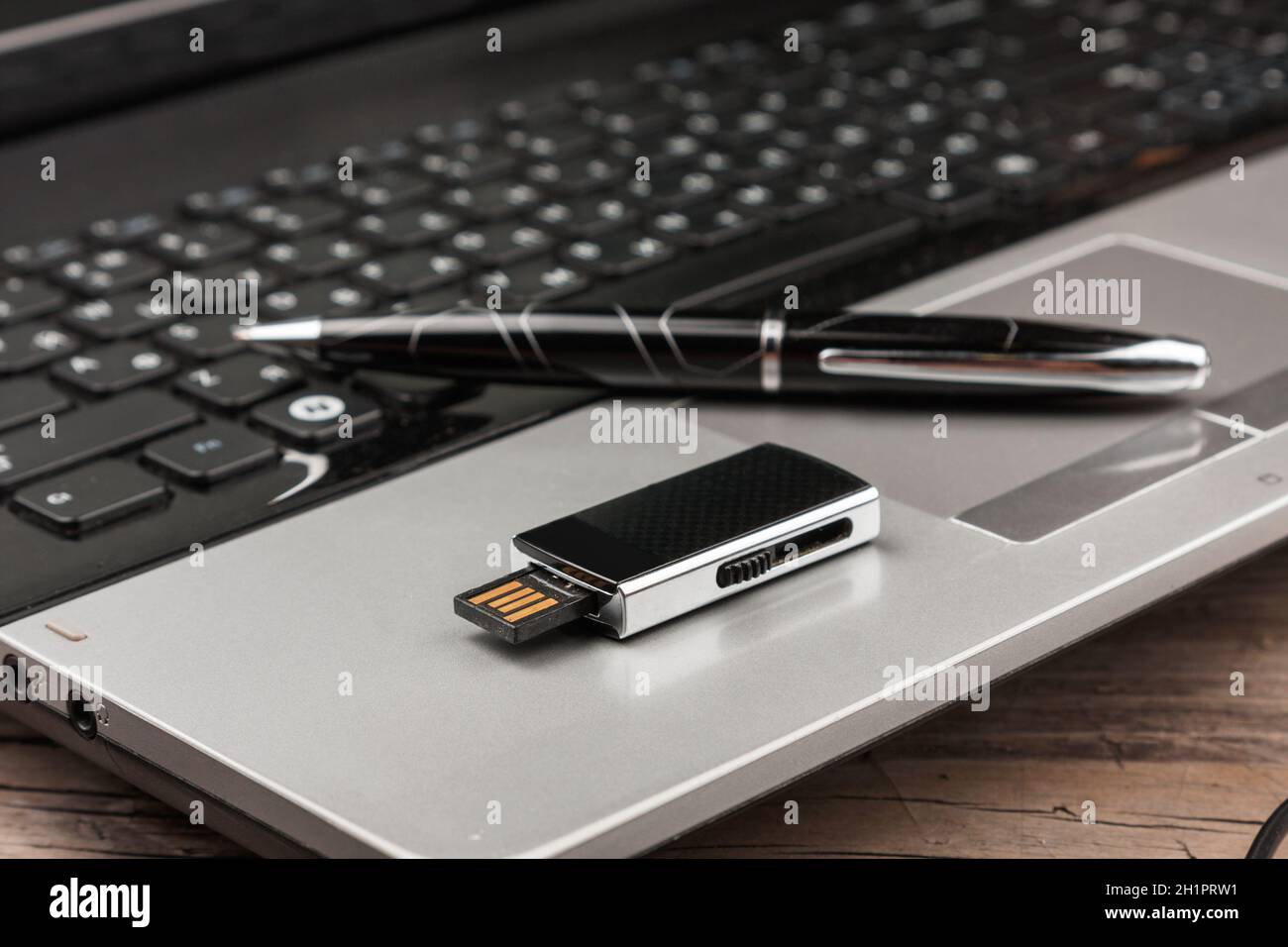 USB Flash drive lying on computer laptop keyboard and pen, as ...