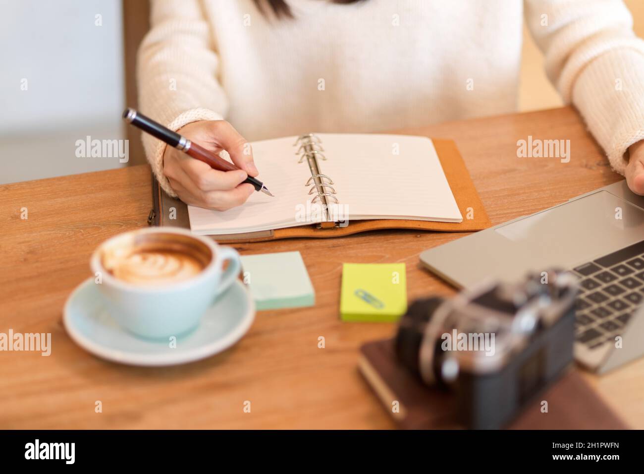 Cropped image of young woman writing her daily routines on her personal ...