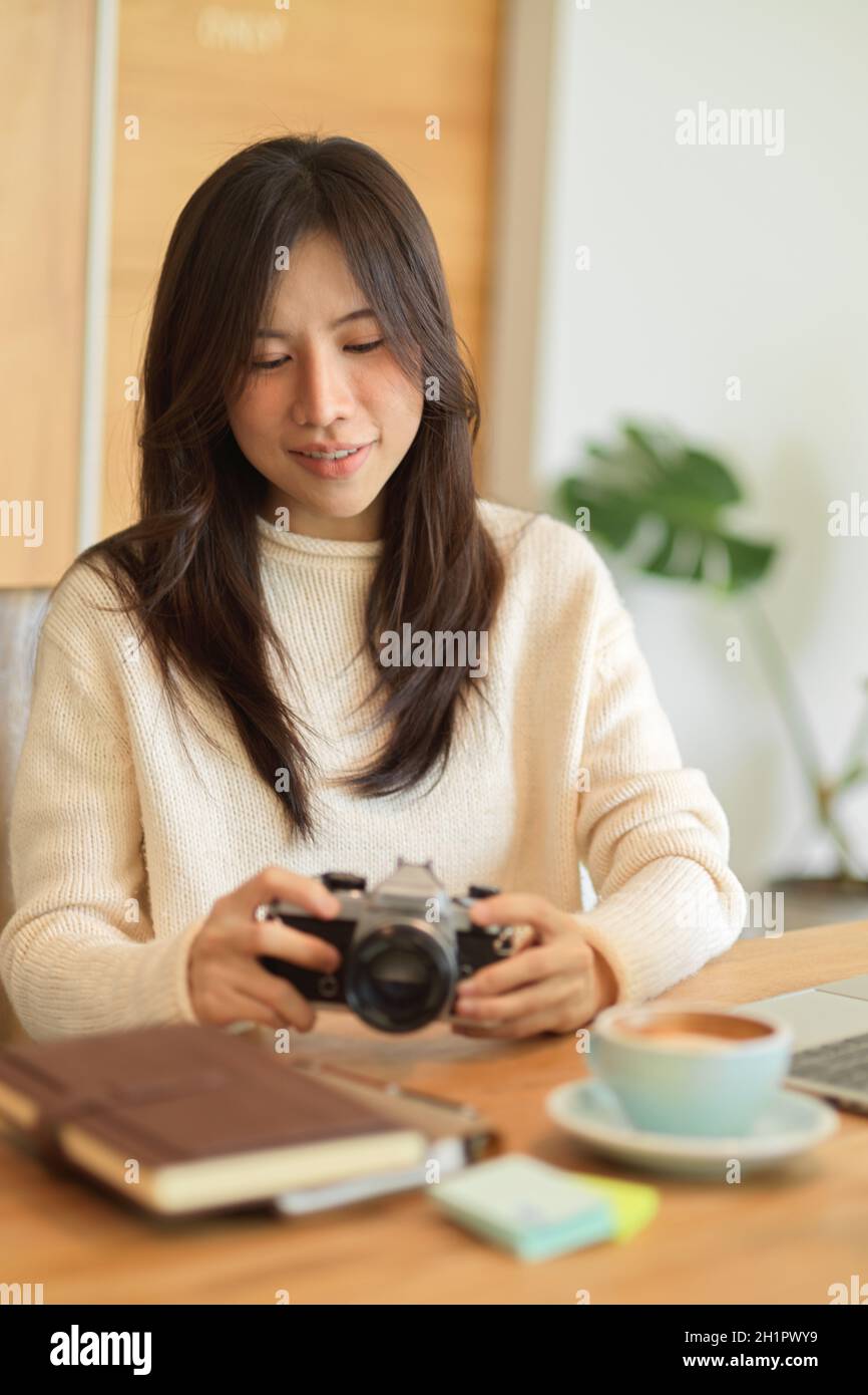 Female freelance photographer looking and checking her photograph on ...