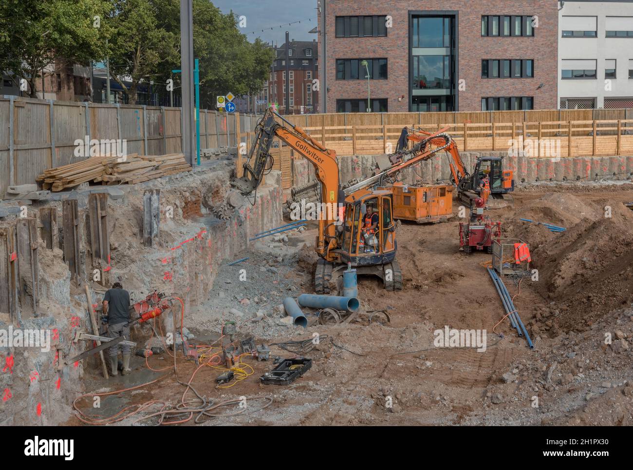 Worker in the foundation trench with construction machinery on the ...