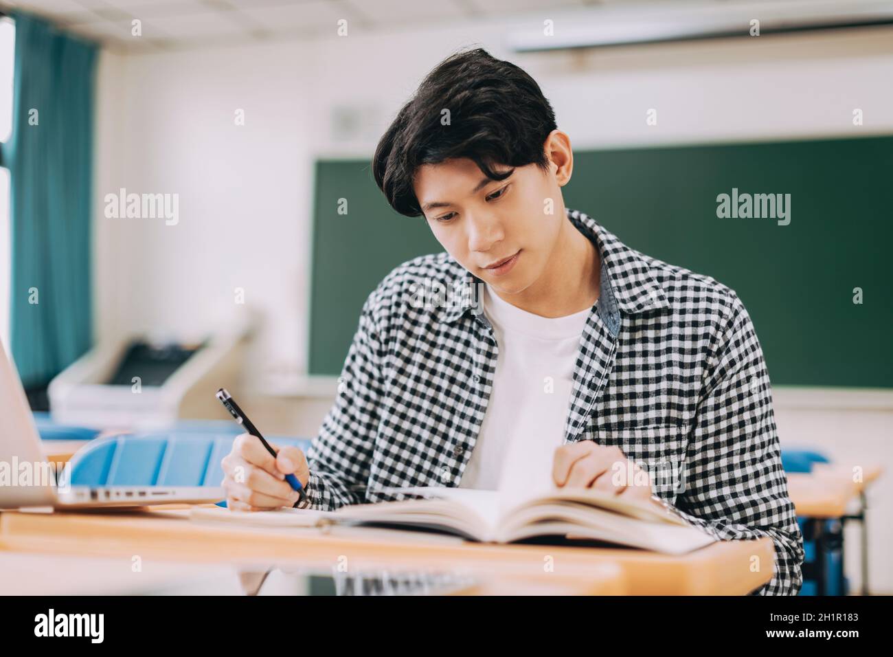 Young cheerful asian student studying in classroom Stock Photo - Alamy