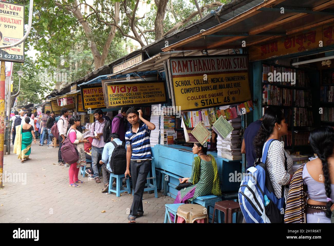 Students check out books at an old street side book stall at College ...