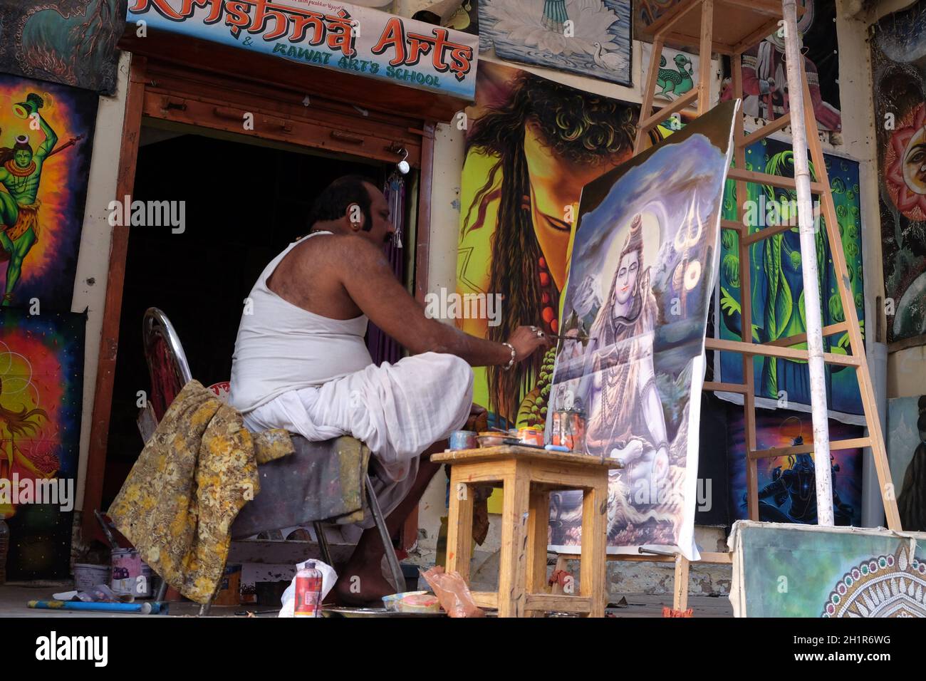 Local artist painting canvas pictures which are sold to tourists ...