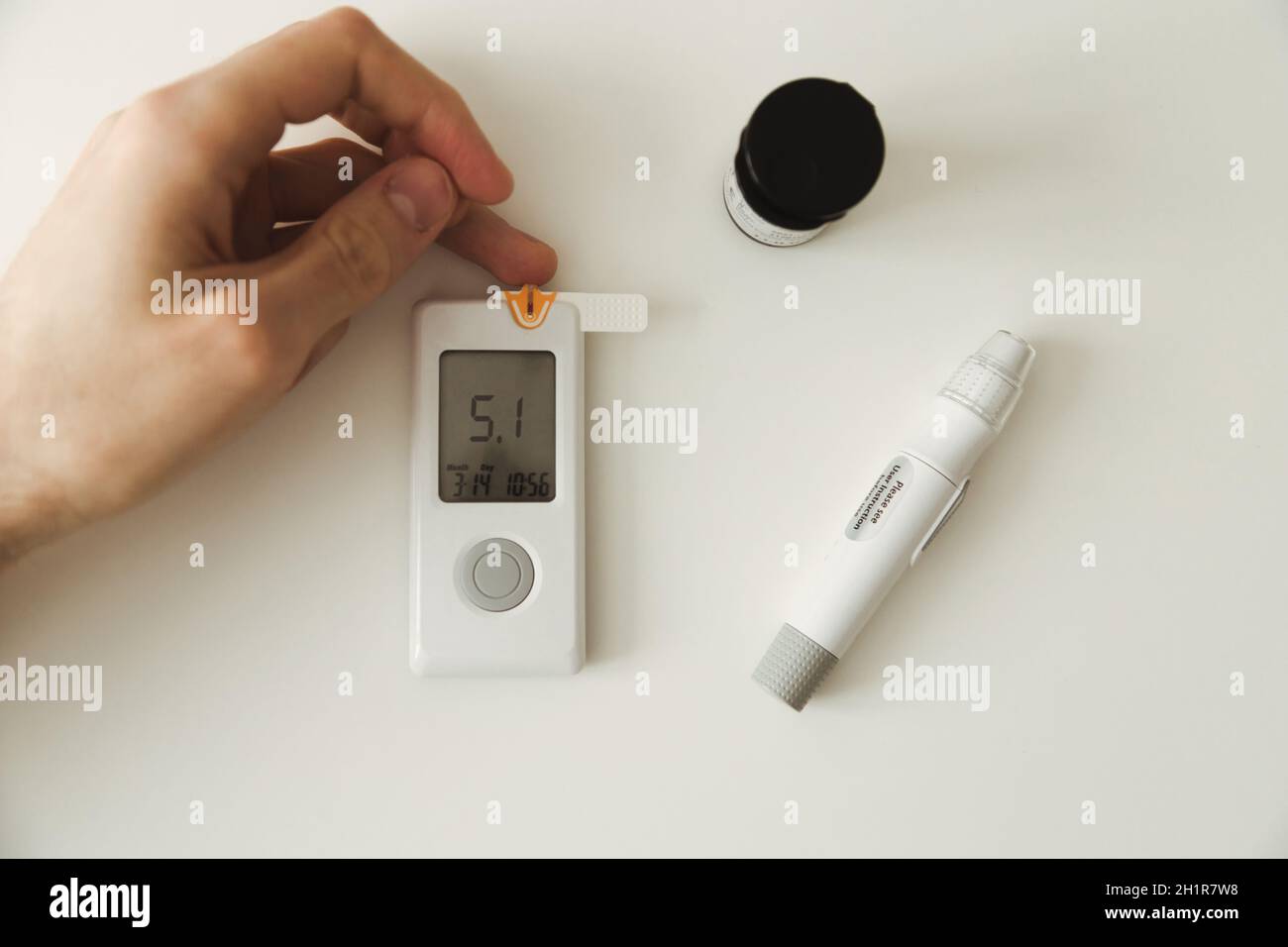 Testing normal blood sugar with glucometer. Man hand and electronic ...