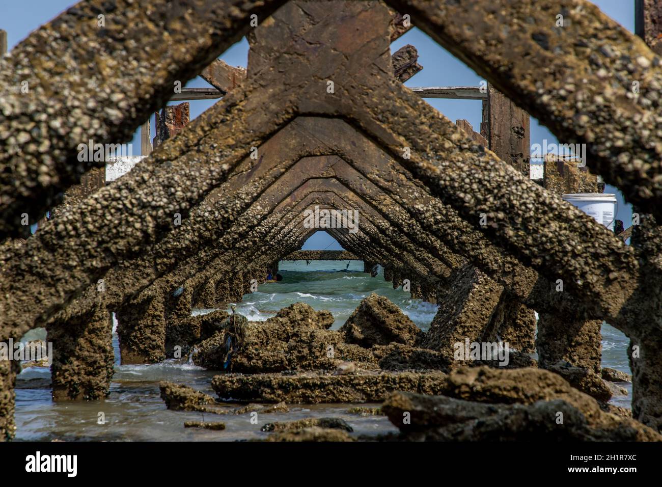 View under at Broken old structure remains of pier in the sea. Small ...