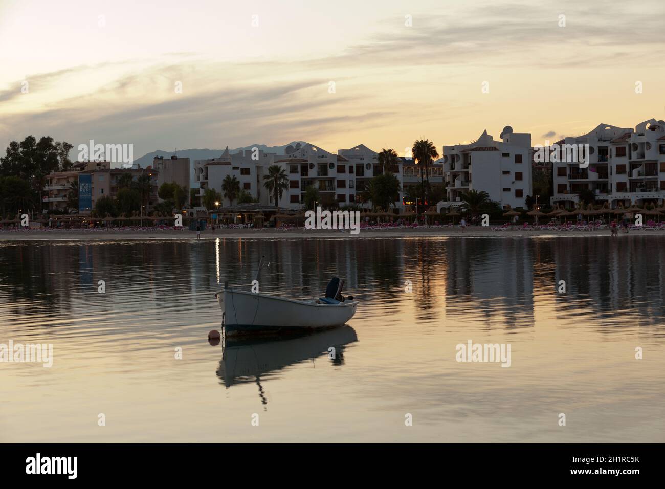Beautiful Sunset scene with a small boat Stock Photo - Alamy