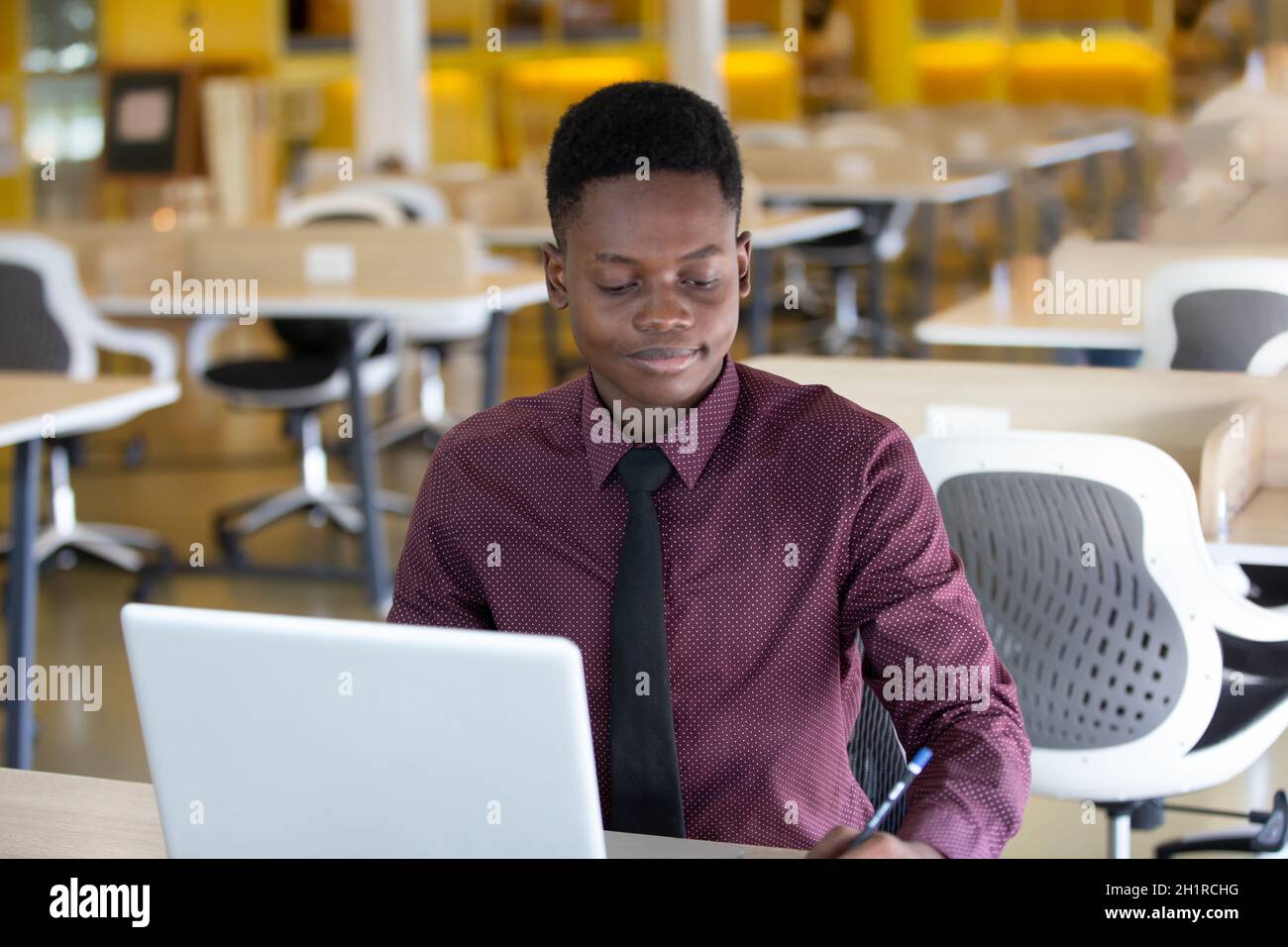 Black man watching educational webinar on laptop, studying, preparing ...