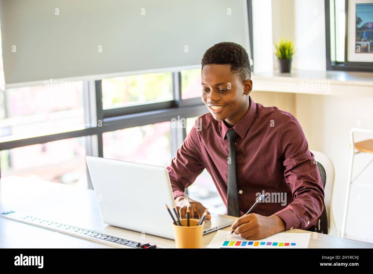 Black man watching educational webinar on laptop, studying, preparing ...