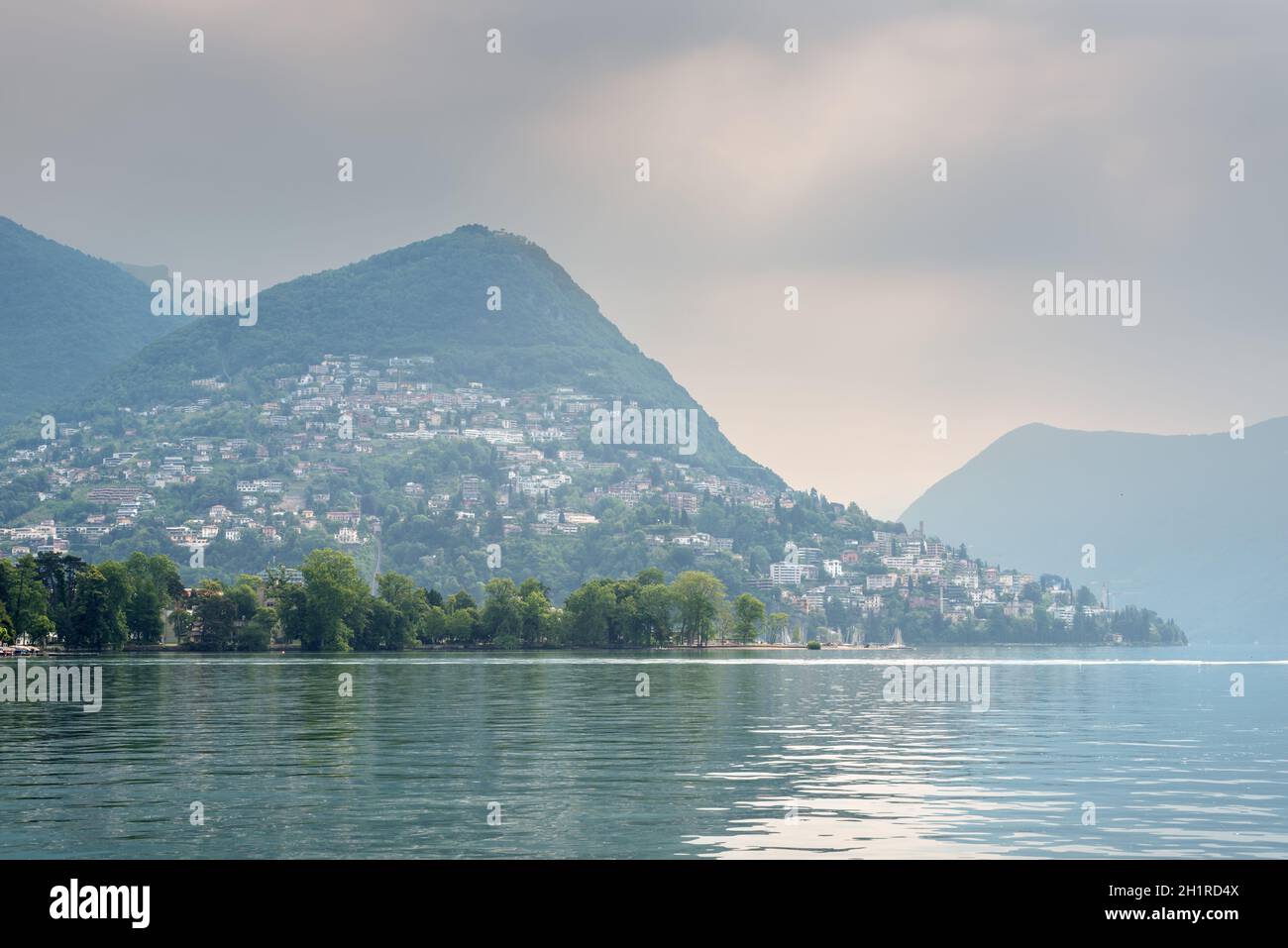 Lake Lugano, mountain Monte Bre in a haze in cloudy rainy weather ...