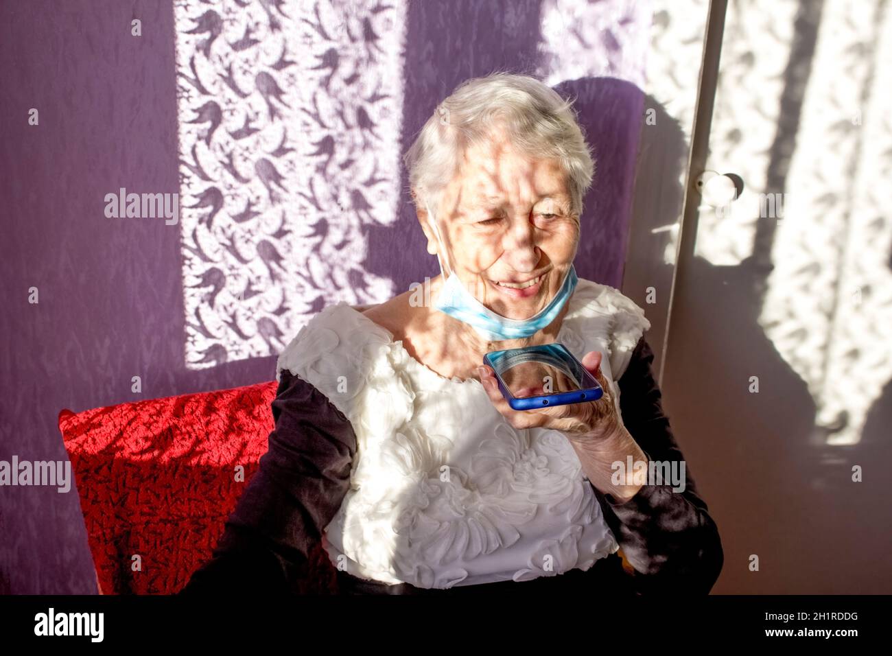Grandmother with smartphone making audio message on gadget, mature ...
