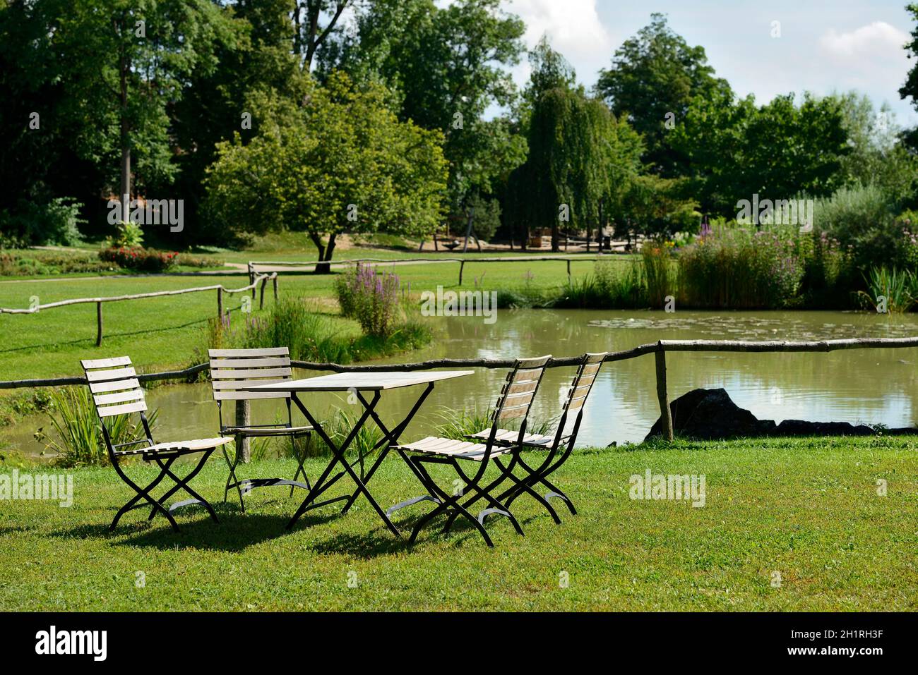 outdoor scene with table and empty chairs in park of baroque castle in ...