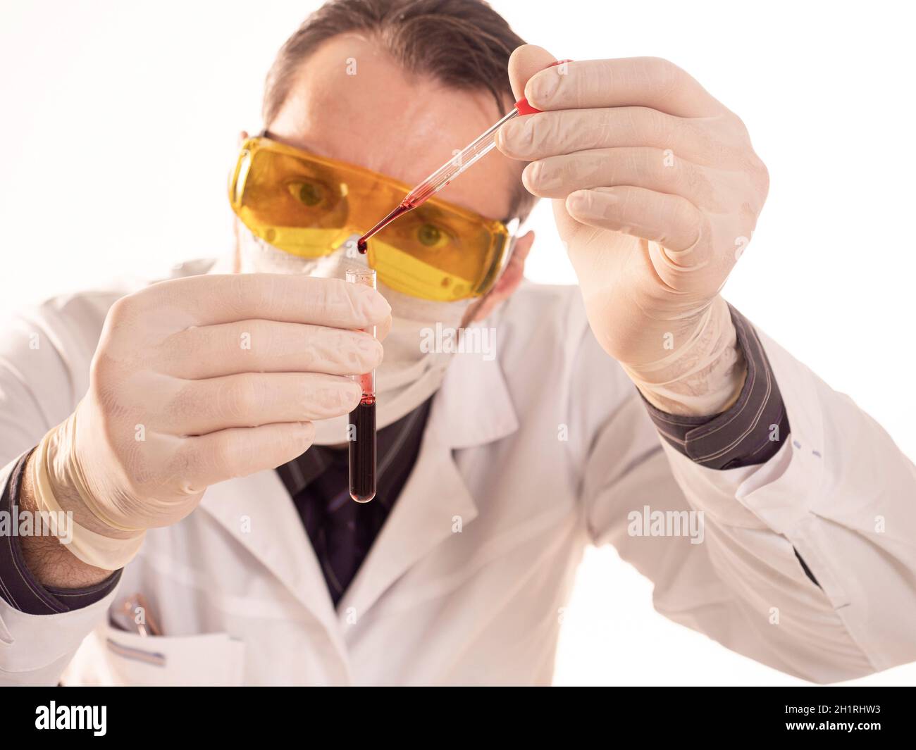 Close-up photo of a researcher drops a blood sample into a test tube ...