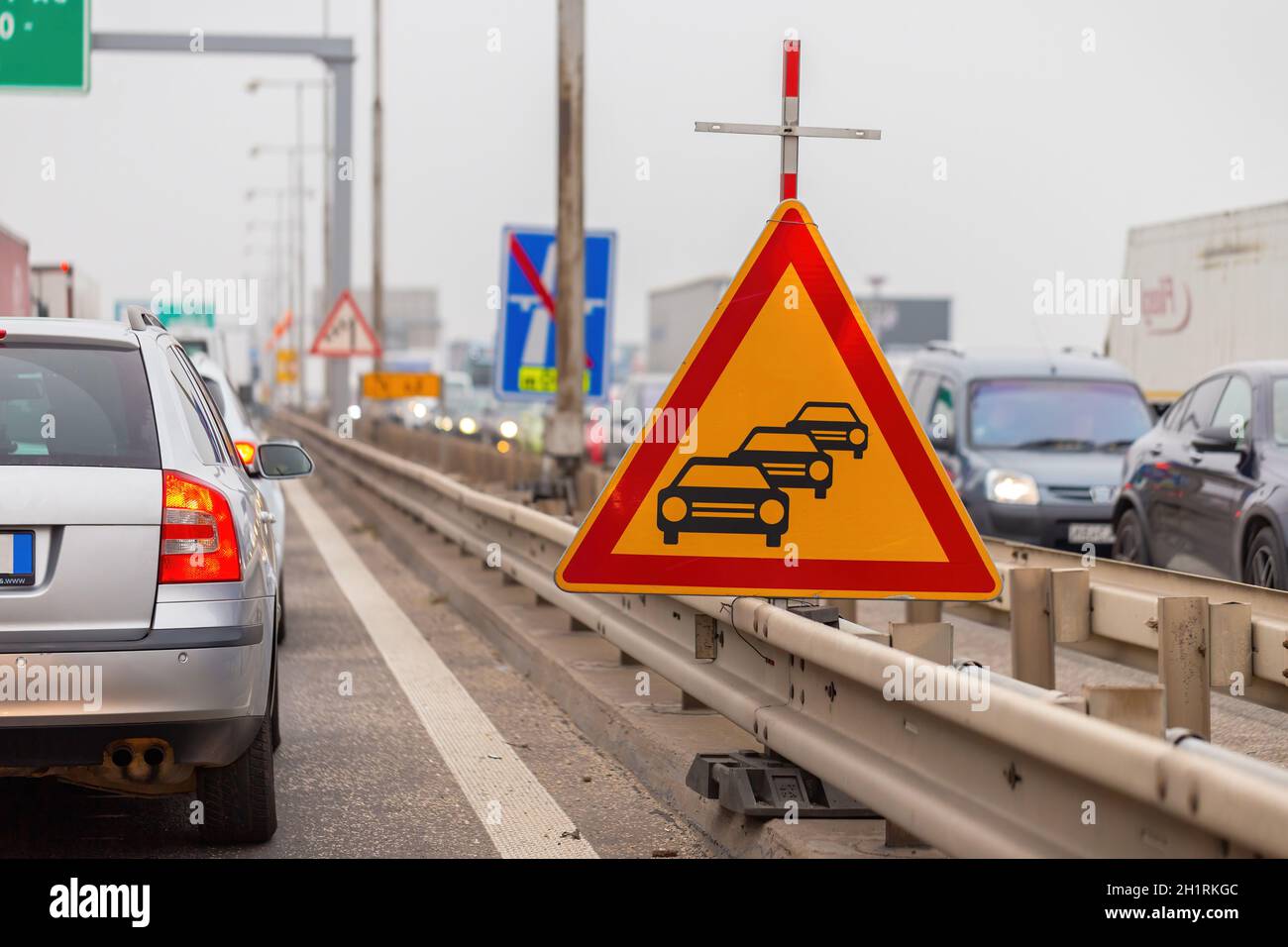 Beware of traffic jam road sign on a freeway with stuck vehicles ...