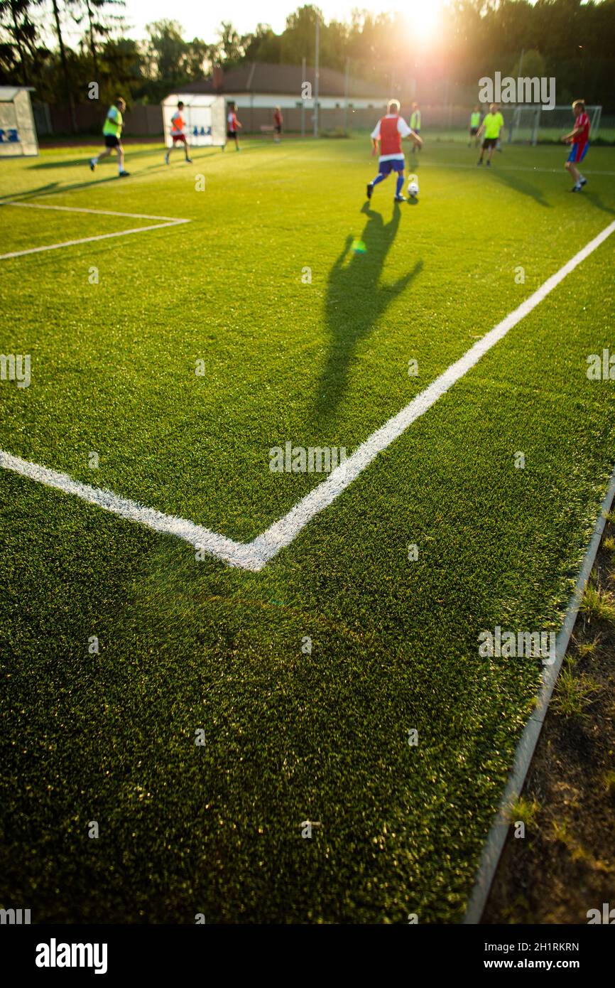 Soccer players on a pitch having match, lit by warm evening sun Stock ...