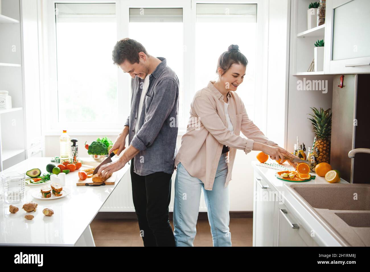 Couple feeling good in the kitchen while cooking a healthy breakfast ...