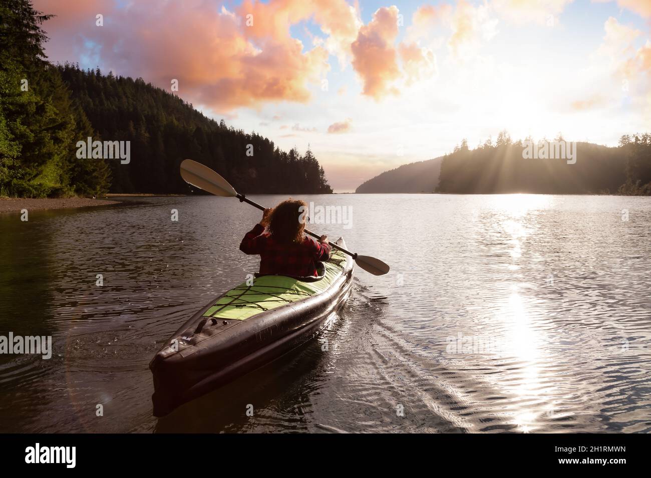 Adventurous Girl kayaking in the Pacific Ocean. Sunset Sky Art Render ...