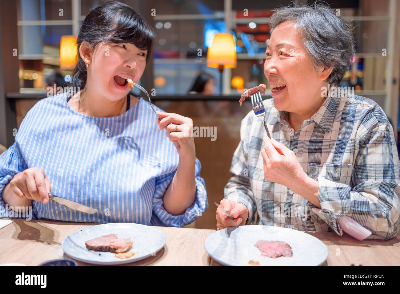 Happy mother and daughter having fun in restaurant Stock Photo - Alamy