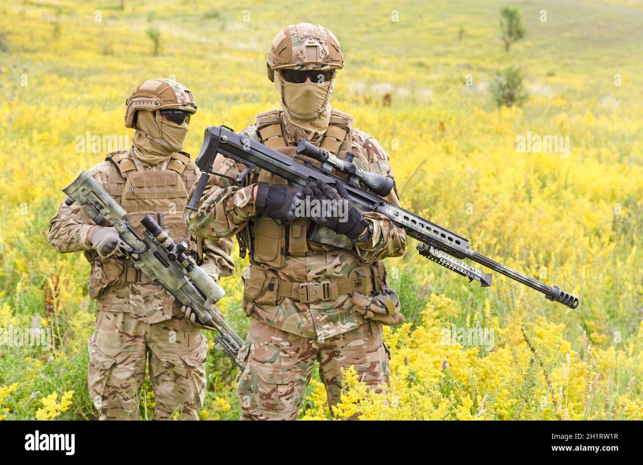 Two armed special forces soldiers with sniper rifles standing in the ...