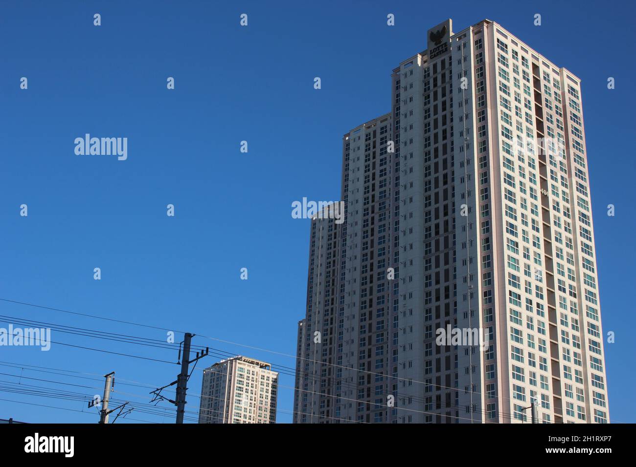 The wide-angle view of a skyscraper commercial building with blue sky ...