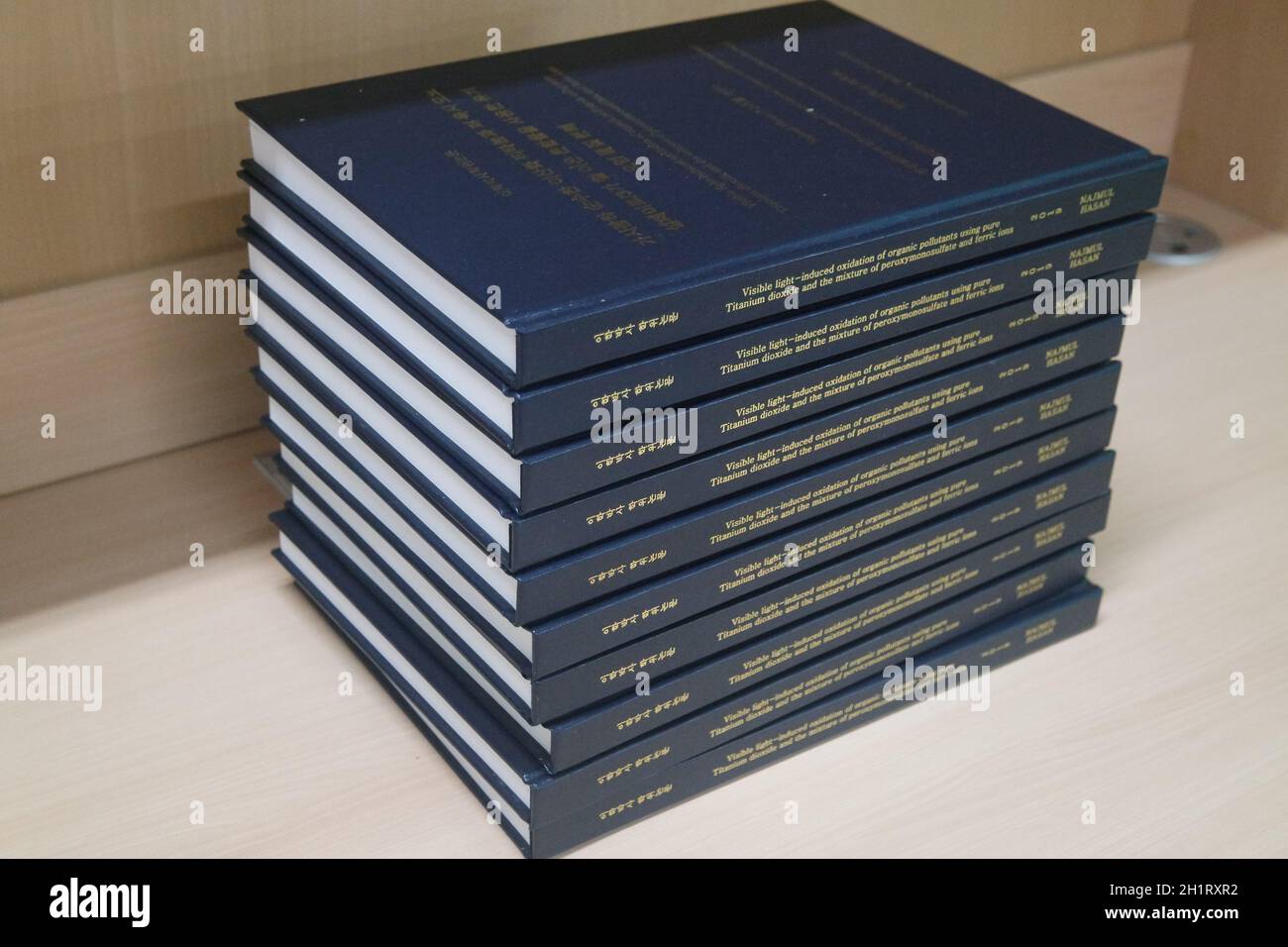 Stack of blue books placed on table. Thesis books with golden words on ...