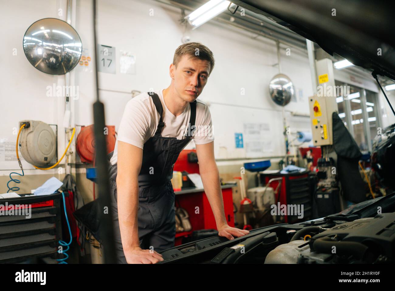 Medium shot portrait of serious handsome professional male car mechanic ...