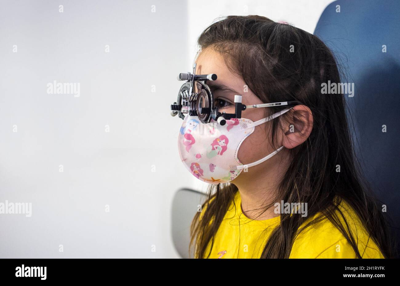 Little girl doing eye test at optometrist. Children caring for eye ...