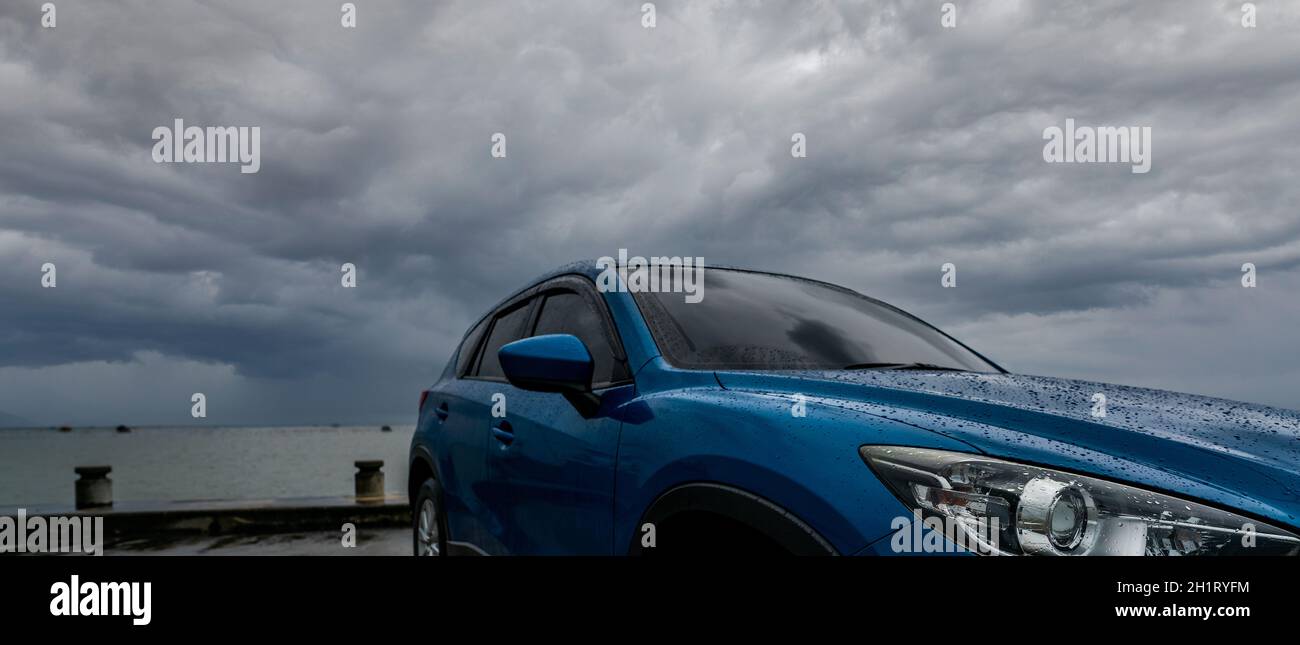 Blue SUV car with water drops parked at parking lot near sea beach ...