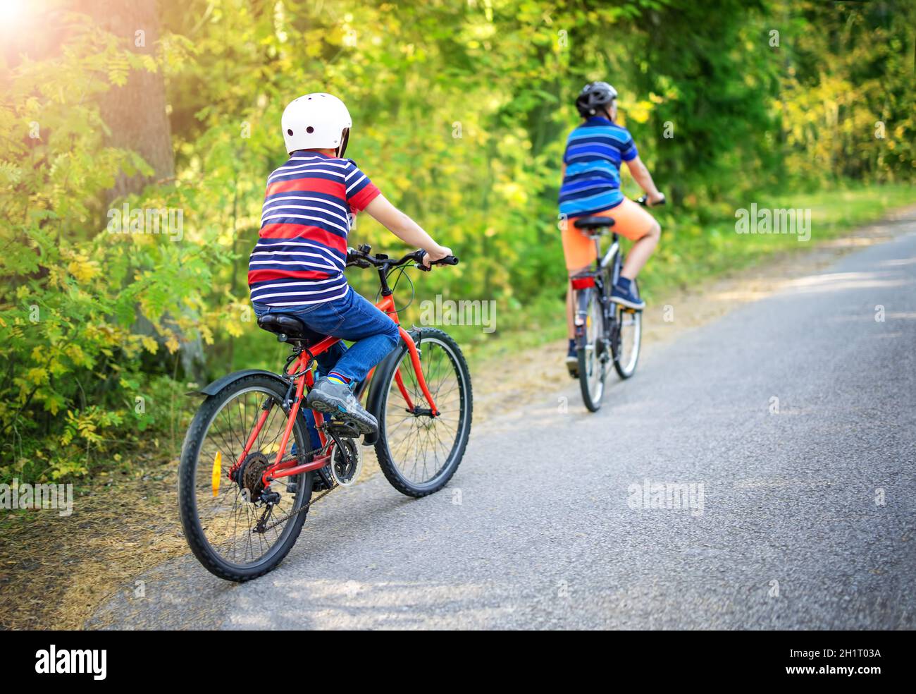 Two boys riding on bicycles on asphalt road in summer. Concept of ...
