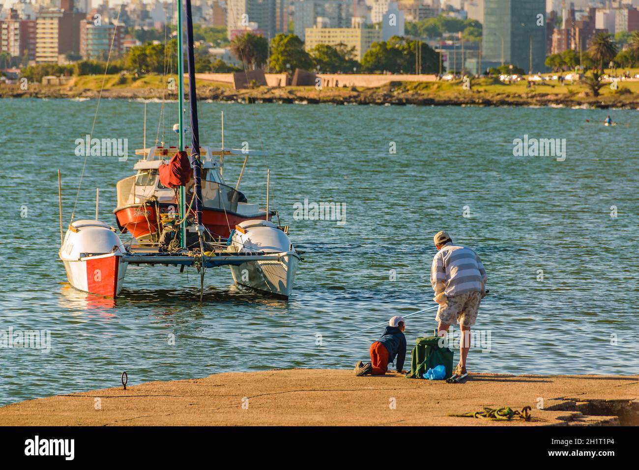 Father and son fishing at coast of river plate river, montevideo ...