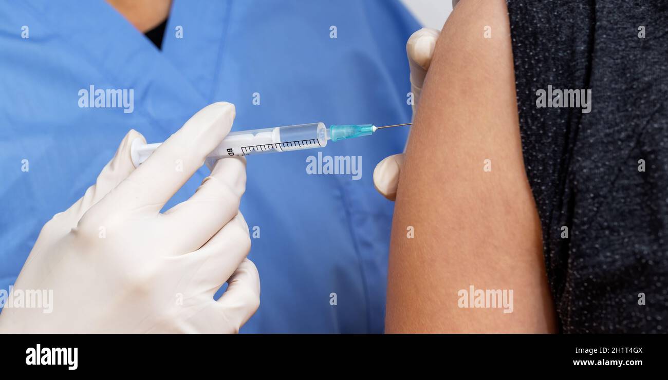 Doctor vaccinating person against virus in close up. Nurse giving ...