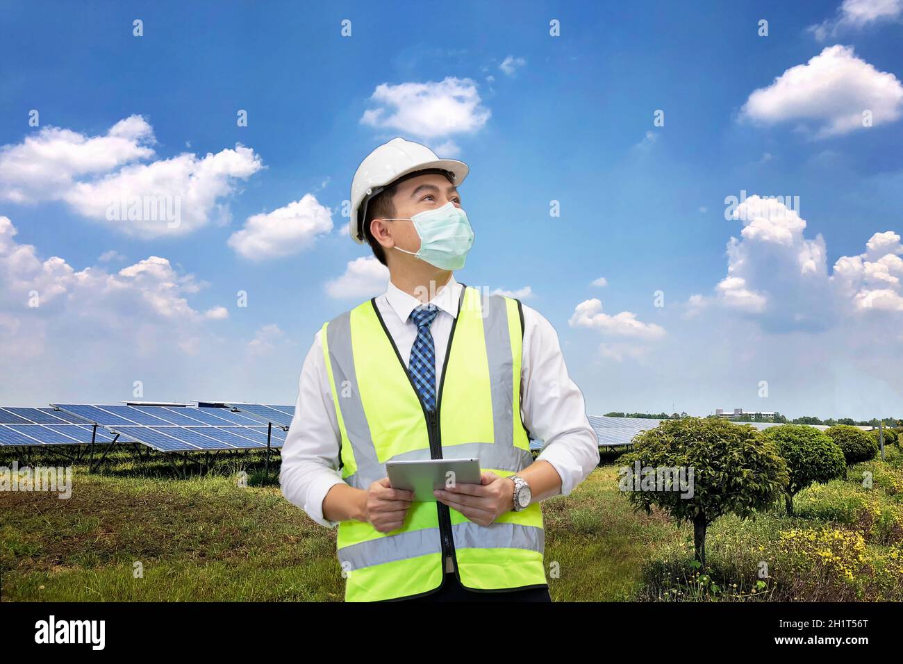 inspection engineer holding tablet computer against solar farm for ...
