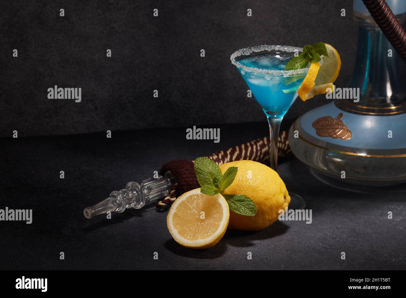 Hookah (shisha) and glass of Blue curacao cocktail with lemon and mint ...