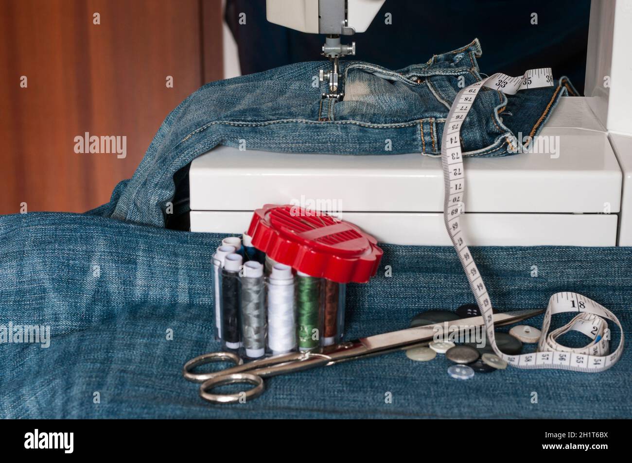 Repair of a blue jeans with a sewing machine Stock Photo - Alamy