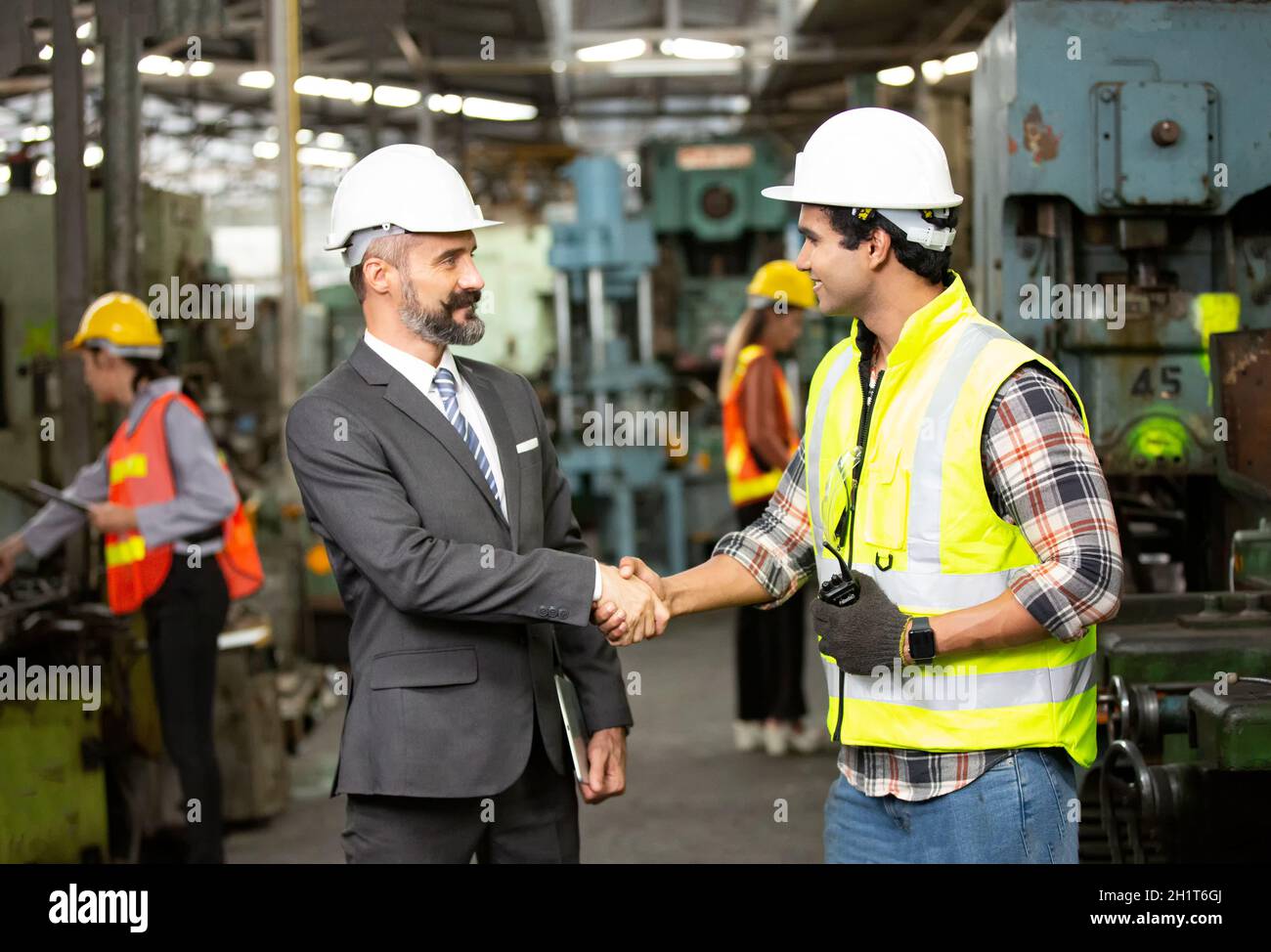 Two Heavy Industry Engineers Stand in Manufacturing Factory, Use ...