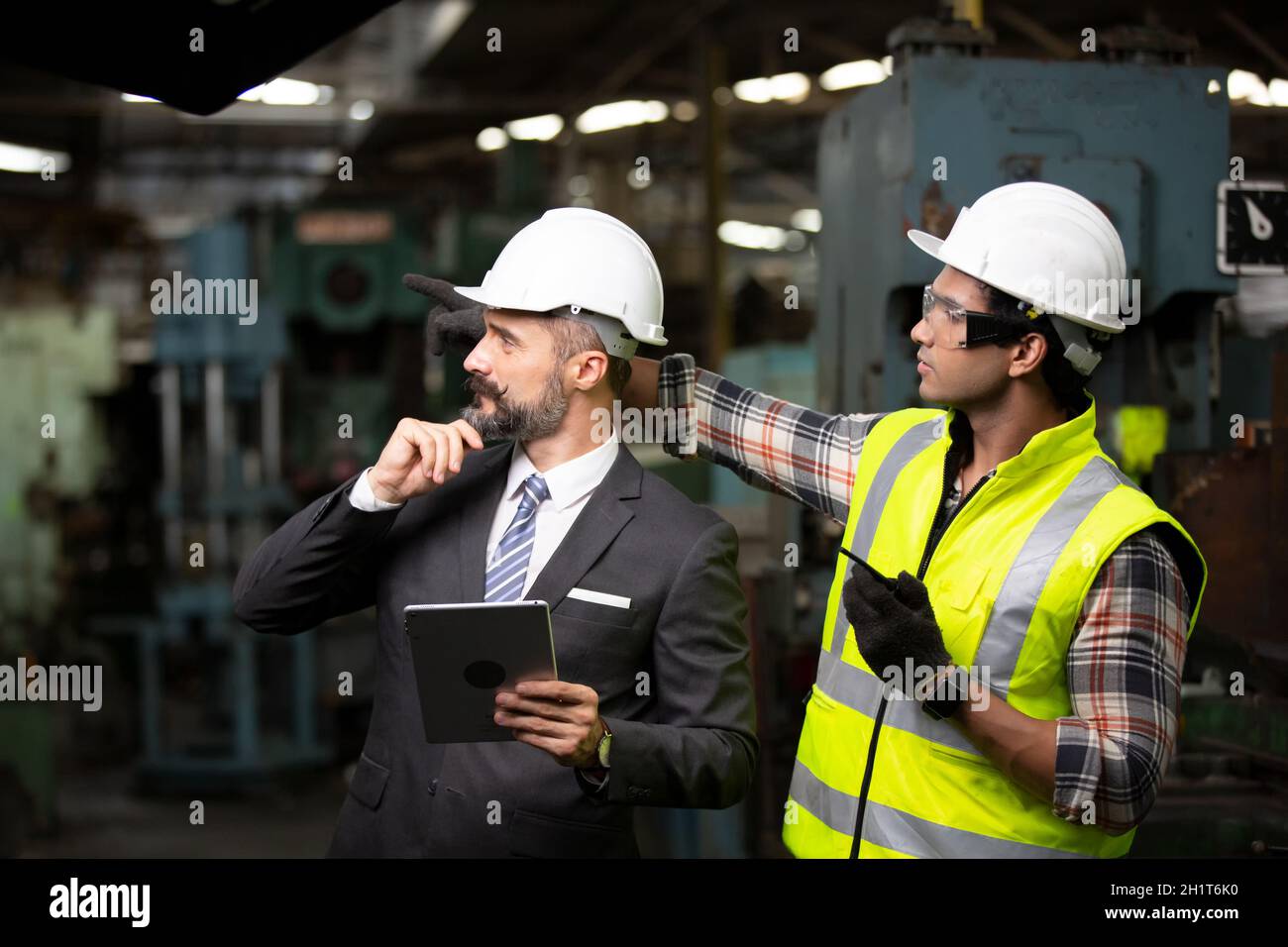 Two Heavy Industry Engineers Stand in Manufacturing Factory, Use ...