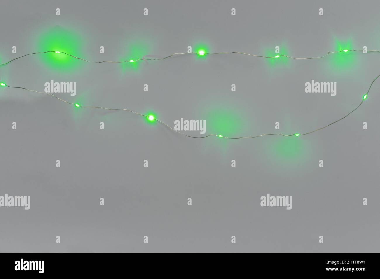 Green color illuminated garland on light gray background Stock Photo ...